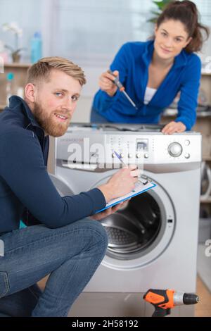 laundry worker taking notes about broken machine Stock Photo - Alamy