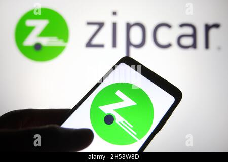 In this photo illustration, a Zipcar logo is seen on a smartphone and a ...