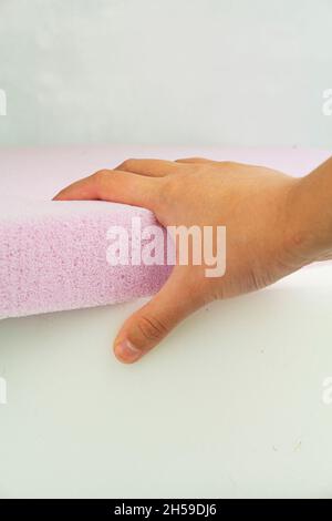 the hand presses on the surface of the rubber foam. Checking hardness ...