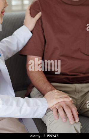 Medical nurse touching arm of patient to support him after explaining ...