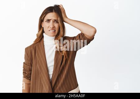 Portrait of confused businesswoman, staring puzzled and frustrated ...