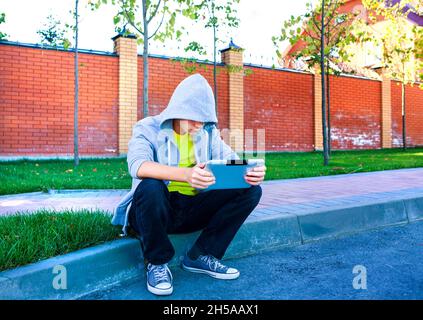 Sad Teenager with Tablet Computer on the Street Stock Photo - Alamy
