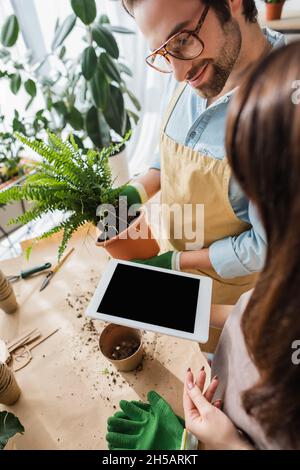 smiling florists holding tablet with blank screen and burgundy roses ...