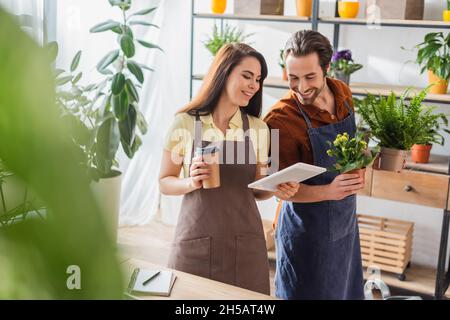 Cheerful florists holding plants in flower shop Stock Photo - Alamy