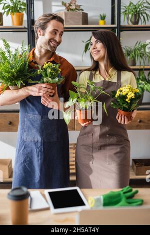Cheerful florists holding plants in flower shop Stock Photo - Alamy