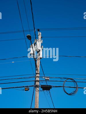 Street light with electricity utility pole and messy electrical wires ...