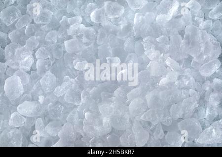 Close up crushed ice in sunlight on blue with copy space. Summer ...