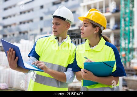 Two builders planning their work in construction plant Stock Photo - Alamy