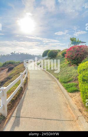 Concrete walkway and bike trail with railings in the residential area ...