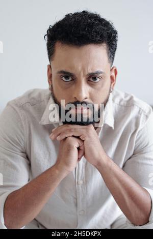 Portrait of angry businessman leaning on table isolated over gray ...