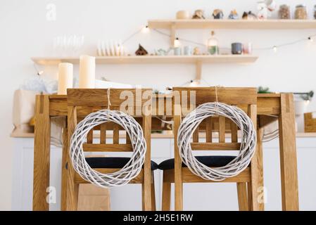 Scandinavian interior style, green wreaths hang on a white sideboard ...
