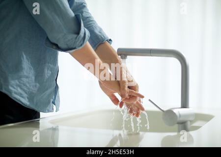 Japanese man washing hands in the kitchen Stock Photo - Alamy