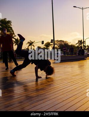 Young person breakdancing in a park surrounded by palm trees in the ...