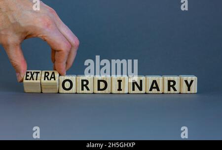 Ordinary or extraordinary symbol. Businessman turnes wooden cubes and ...
