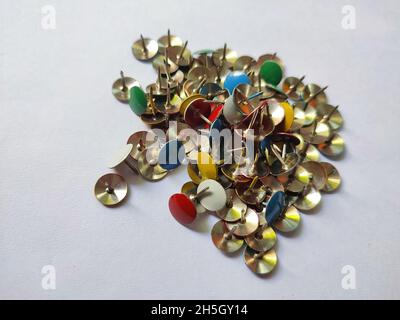 Pile of brass drawing pins on white background Stock Photo - Alamy