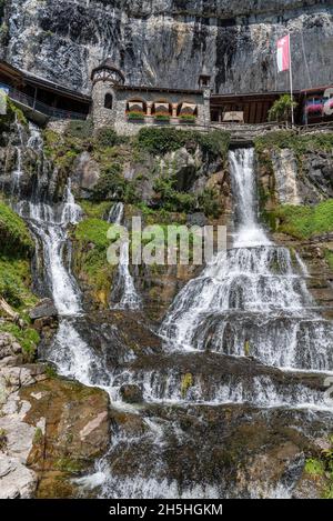 Ensemble of buildings with waterfall in front of the Saint Beatus Caves ...