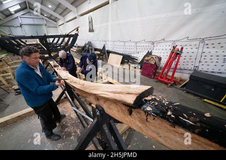 A team of volunteers work on the keel of the 88ft-long replica of the ...