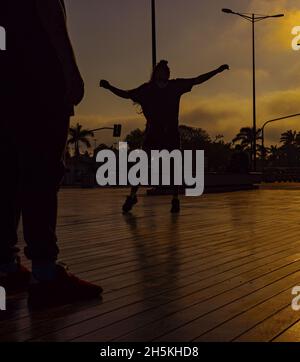 Young person breakdancing in a park surrounded by palm trees in the ...