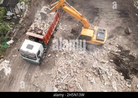 Excavator bucket loads industrial debris into truck. Process of ...