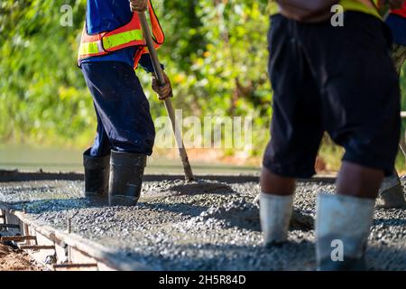 Pouring wet concrete while paving a driveway at construction site Stock ...