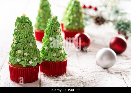 Christmas tree cupcakes on snow wooden table Stock Photo - Alamy