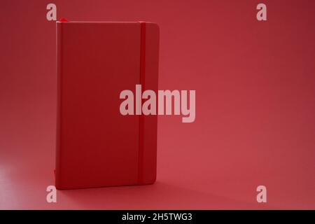 Red copybook with elastic band on wooden background Stock Photo - Alamy