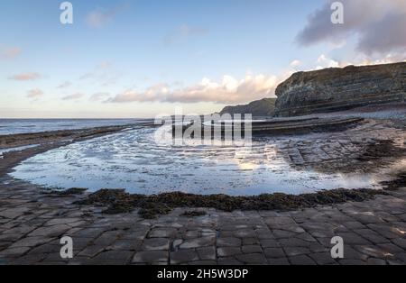 Cliffs and rock strata visible at low tide on the beach at East ...