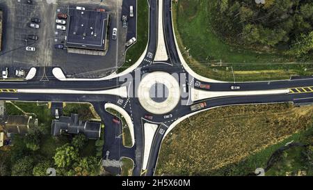 Aerial shot of a roundabout surrounded by greenery under the sunlight ...