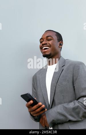 smiling businessman in formal wear standing with hand in pocket near ...