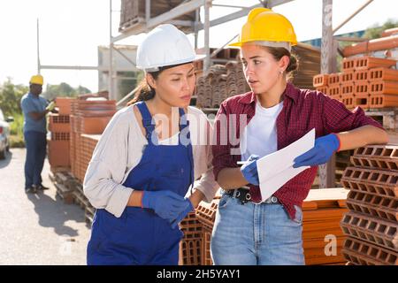 Couple of female wokers checking order list Stock Photo - Alamy