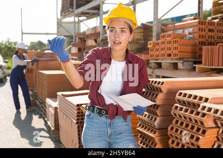 Woman manager leads the accounting of materials at construction site ...