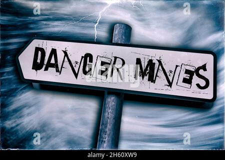 A warning sign with 'Danger Mines' written on it at a mine field on the ...
