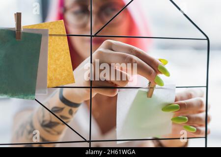 Young businesswoman with sticky note papers on clipboard against blue ...