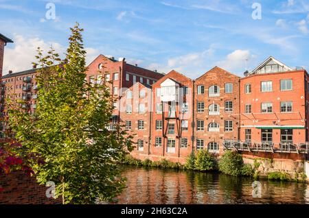 Old brick warehouses converted into lofts along a river on a sunny ...