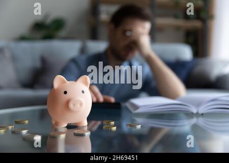 Young sad man analyzing home finances while gesturing with hand and ...