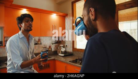 Two Indian friends talking while drinking coffee in the kitchen Stock ...