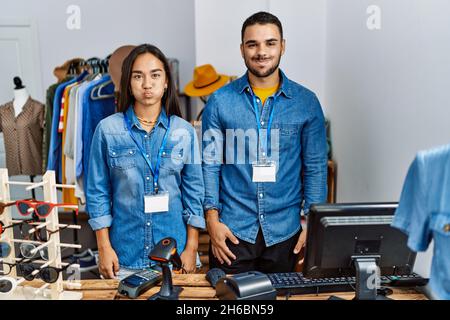Young interracial people working at retail boutique smiling positive ...