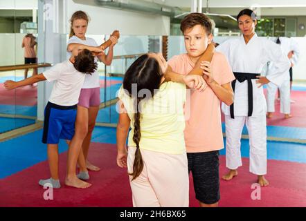 Kids in pair exercising self-defense movements Stock Photo - Alamy