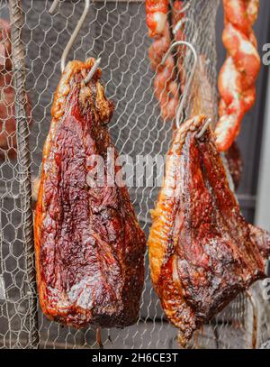 grilled pieces of pork meat getting cut off by a hand Stock Photo - Alamy