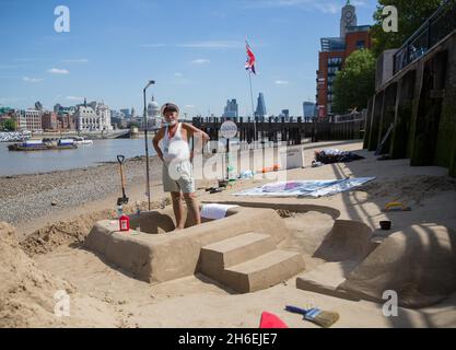 A sculptor creates a sand shower to cool down in central London this ...