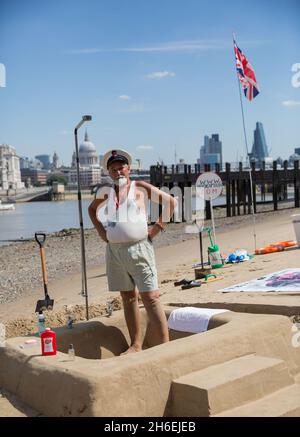A sculptor creates a sand shower to cool down in central London this ...