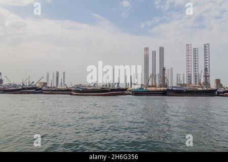 Boats, oil derricks and cranes in the Khalid port in Sharjah, United ...