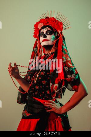 Young woman in calavera style with Mexican skull make-up on her face ...