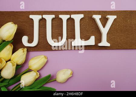 July alphabet letter and tulip flower with space copy on purple ...