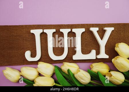 July alphabet letter and tulip flower with space copy on purple ...