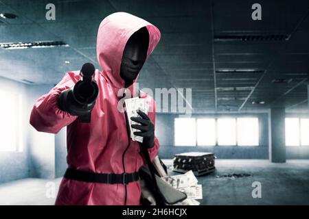 Criminal man in pink uniform and a hidden mask holding the money ...