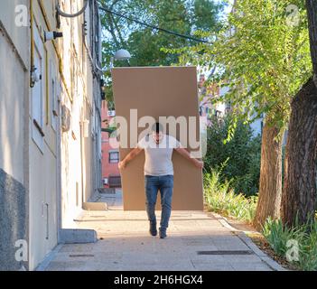 Young worker carrying plasterboard sheets Stock Photo - Alamy