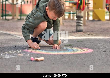 Children paint a rainbow on the asphalt. Selective focus. Kids Stock ...