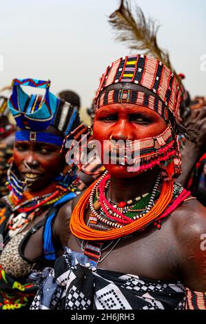 Traditional dressed women of the Jiye tribe dancing and singing ...
