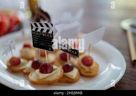 Light snacks in a plate on a buffet table. Assorted mini canapes ...
